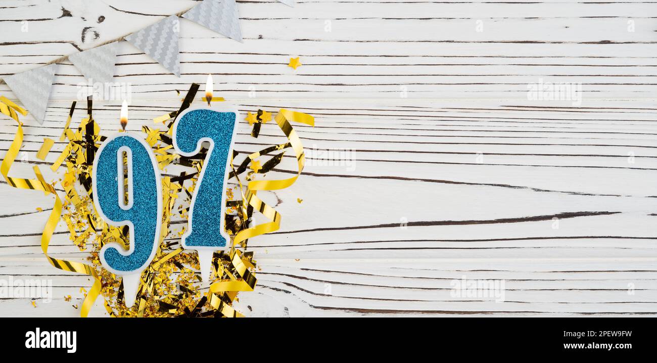 Number 97 blue celebration candle on white wooden background. Happy ...