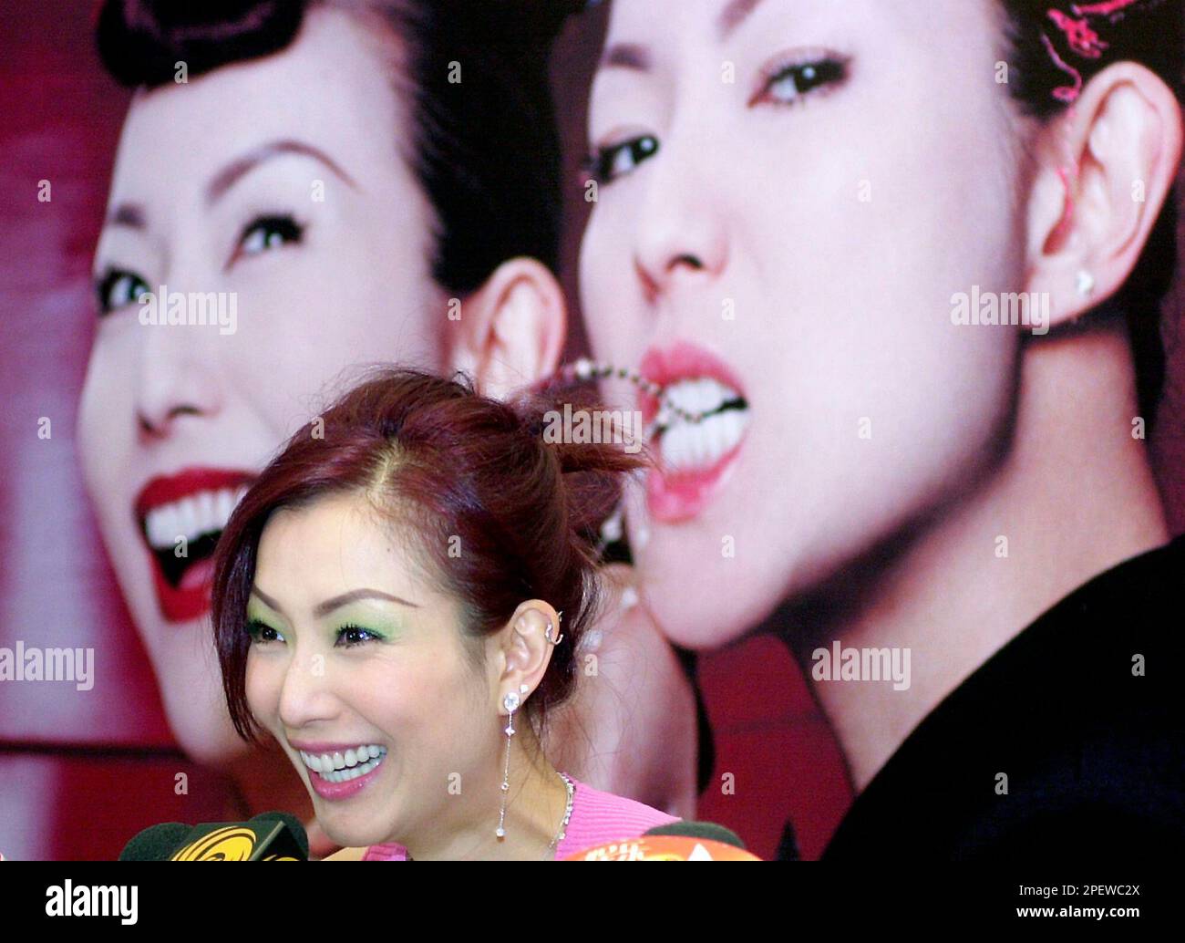 Hong Kong singer Sammi Cheng poses in front of a poster of herself at a ...