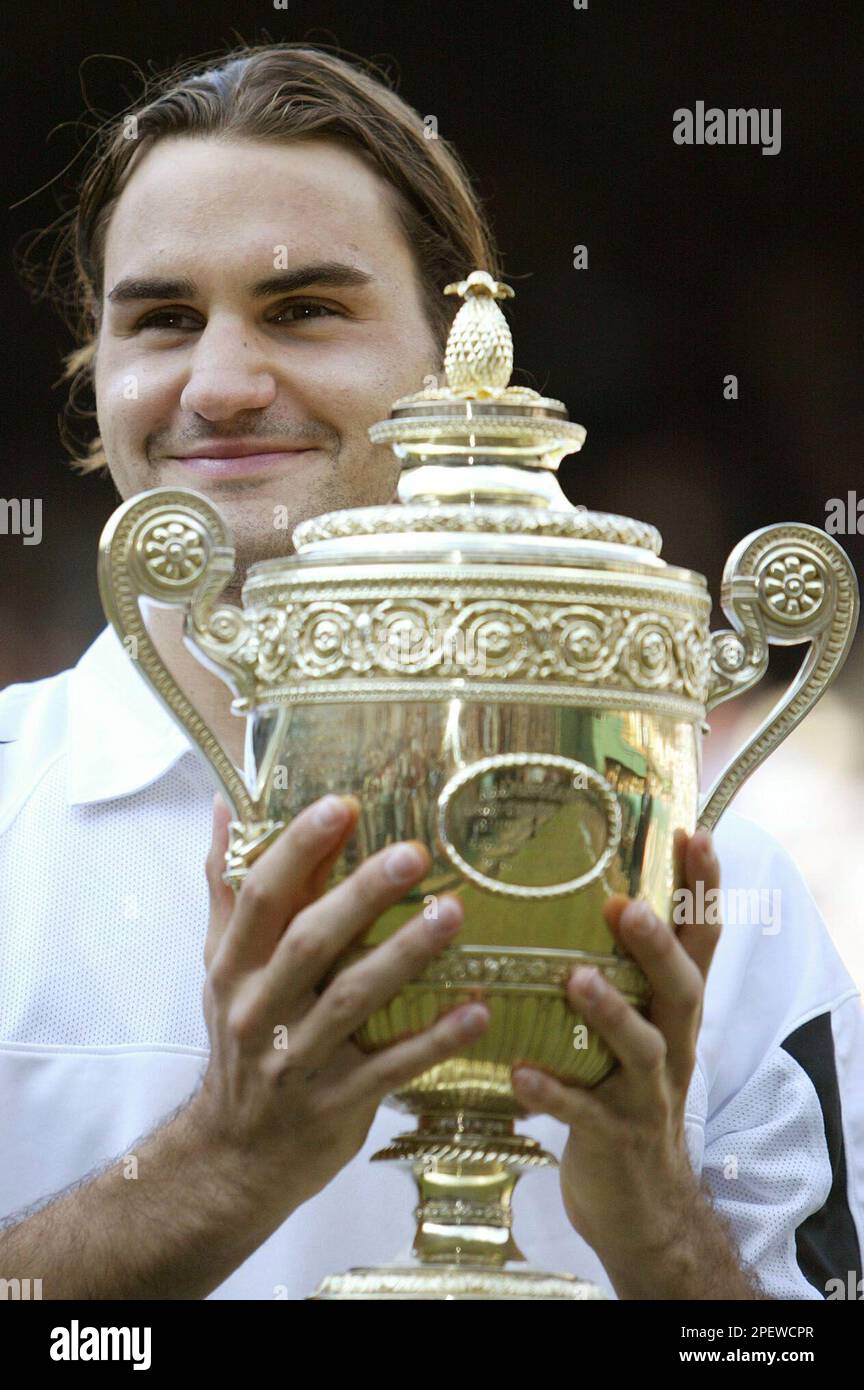 Roger Federer holds the trophy after defeating Andy Roddick in the Men ...