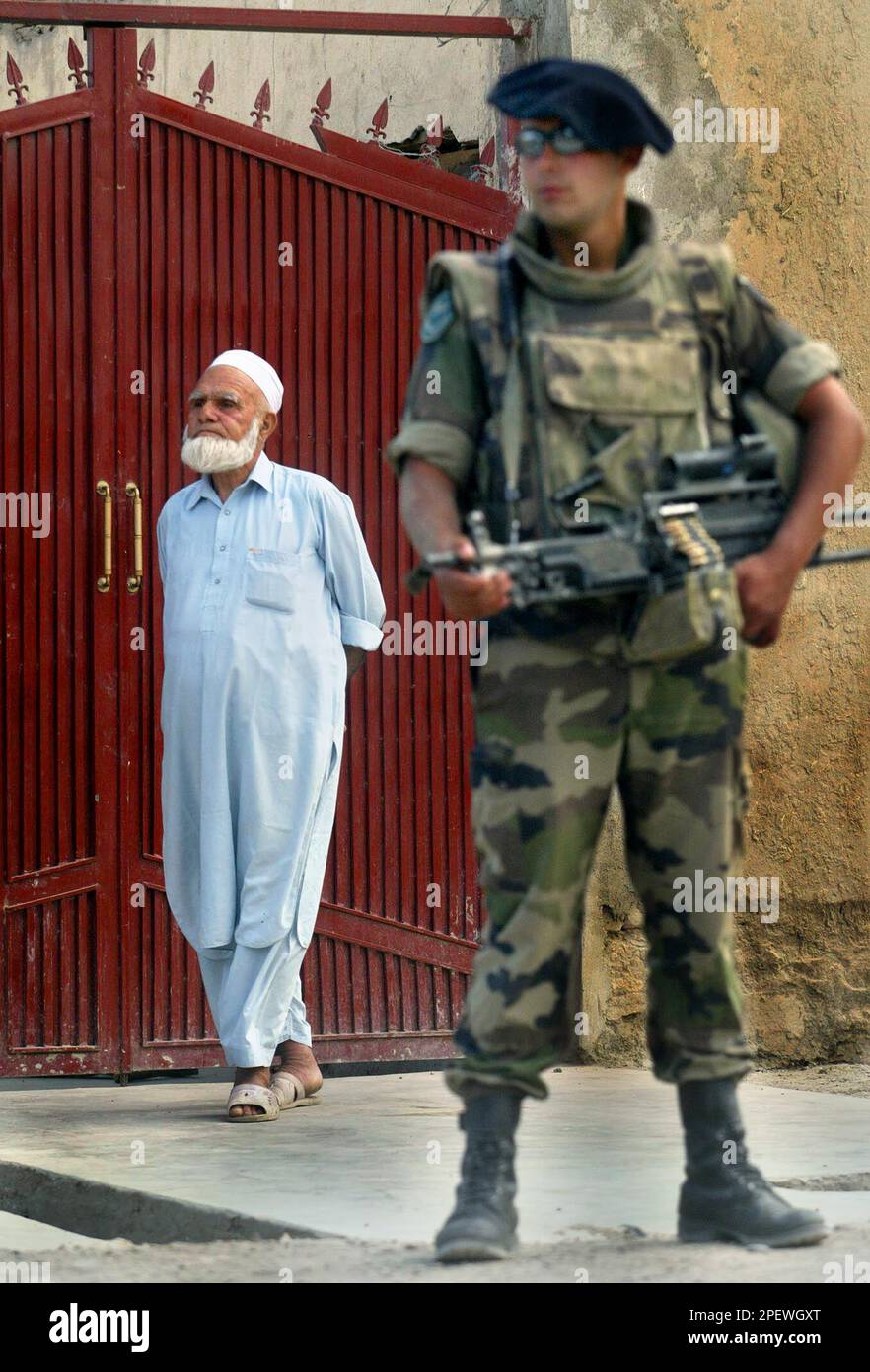 A French soldier of ISAF stands guard for his other colleagues during a ...