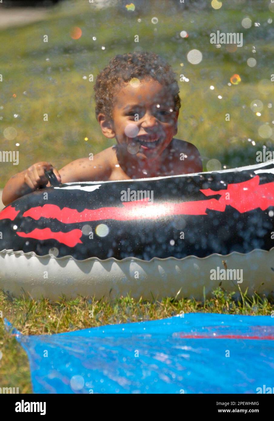 Collin Reece, 6, laughs as he lands short of a plastic water slide in ...