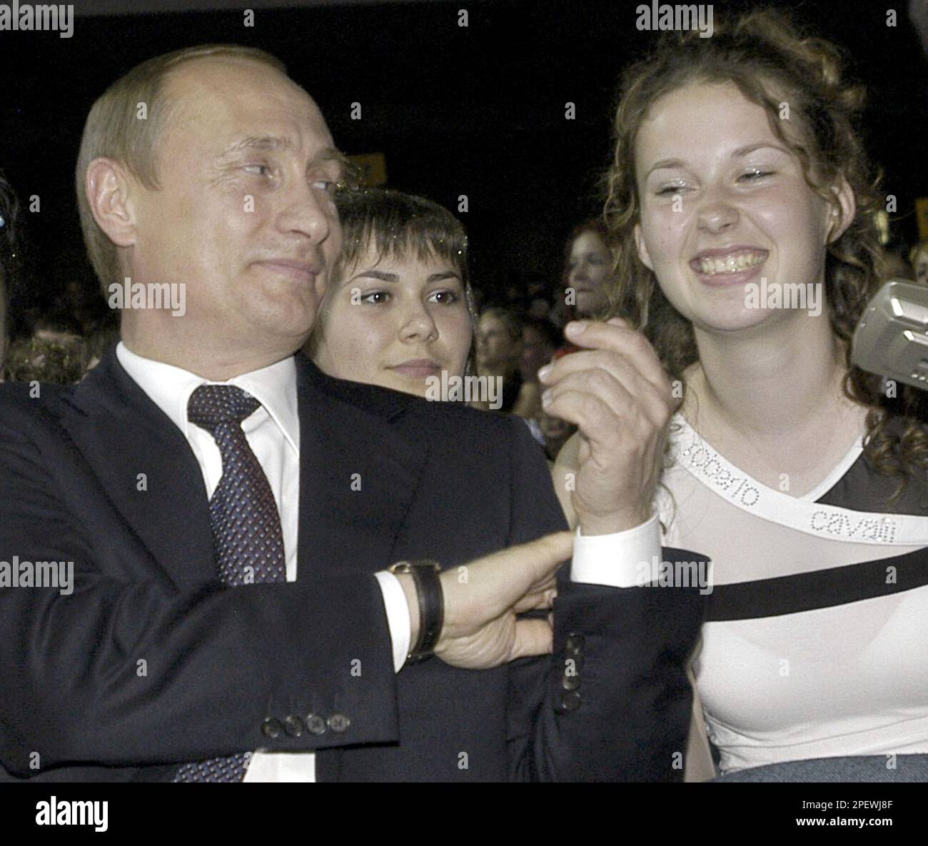 Russian President Vladimir Putin surrounded by school graduates watches ...