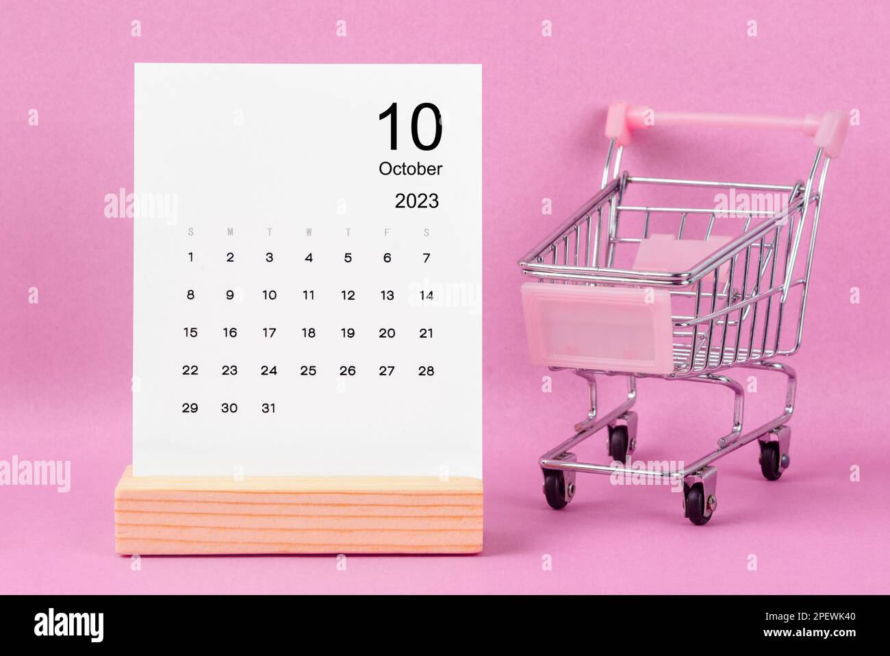 October 2023 Monthly calendar with shopping cart against pink ...