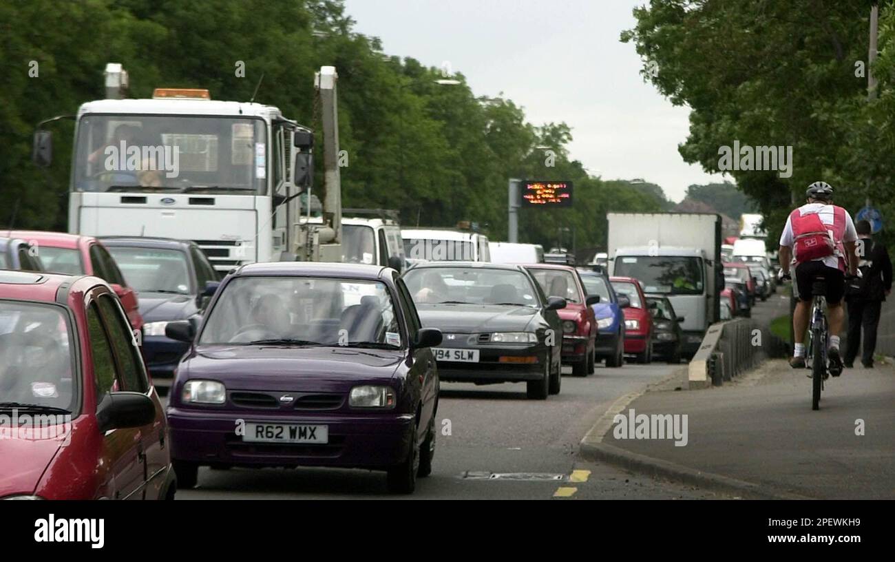 A cyclist goes up the pavement with traffic snarled in north London ...