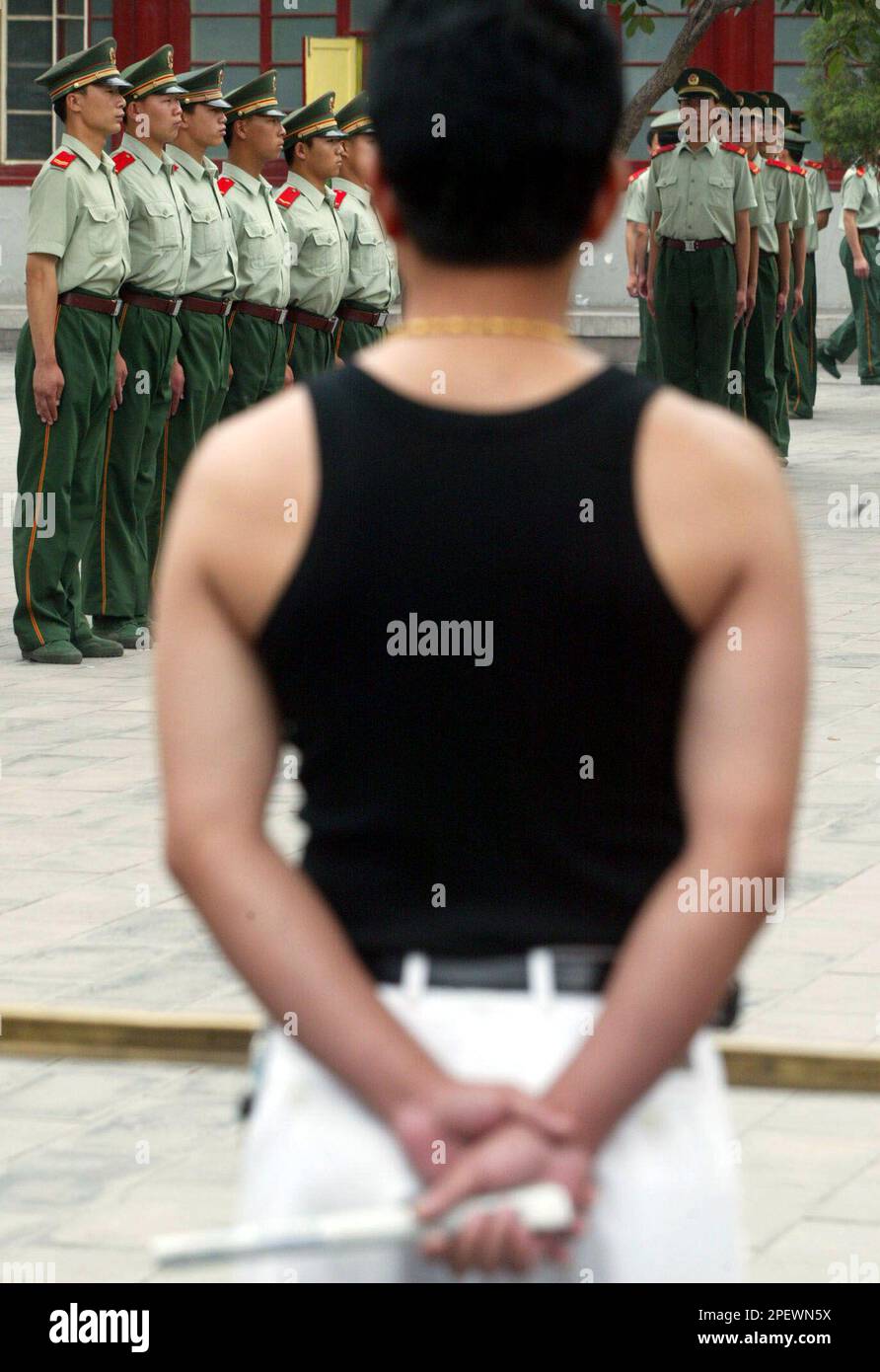 A man watches paramilitary officer going through marching drills at a ...