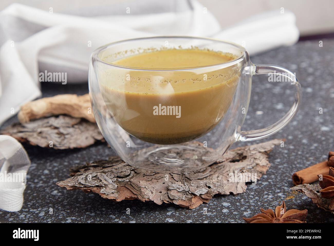 Cup of natural masala tea with spices on tree bark. Healthy traditional ...