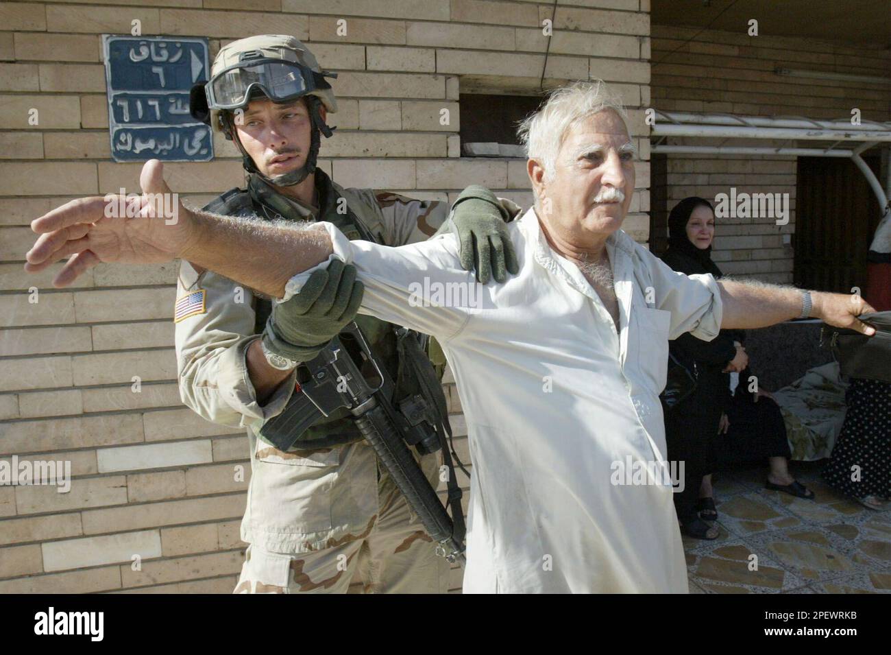 A U.S. Army soldier searches an Iraqi man during a weapons raid in the ...