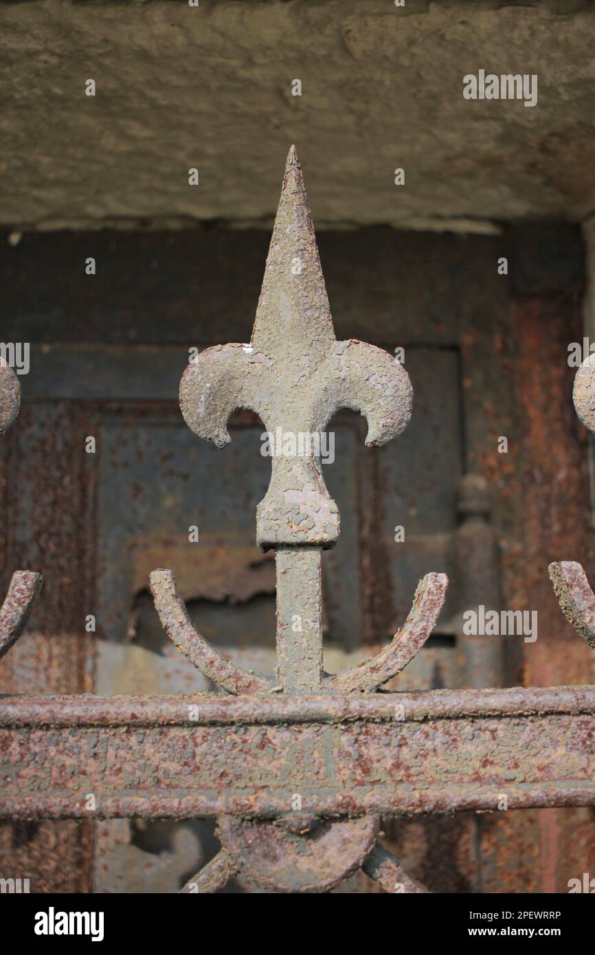 A vintage and fancy metal gate with rusted decorations and security ...