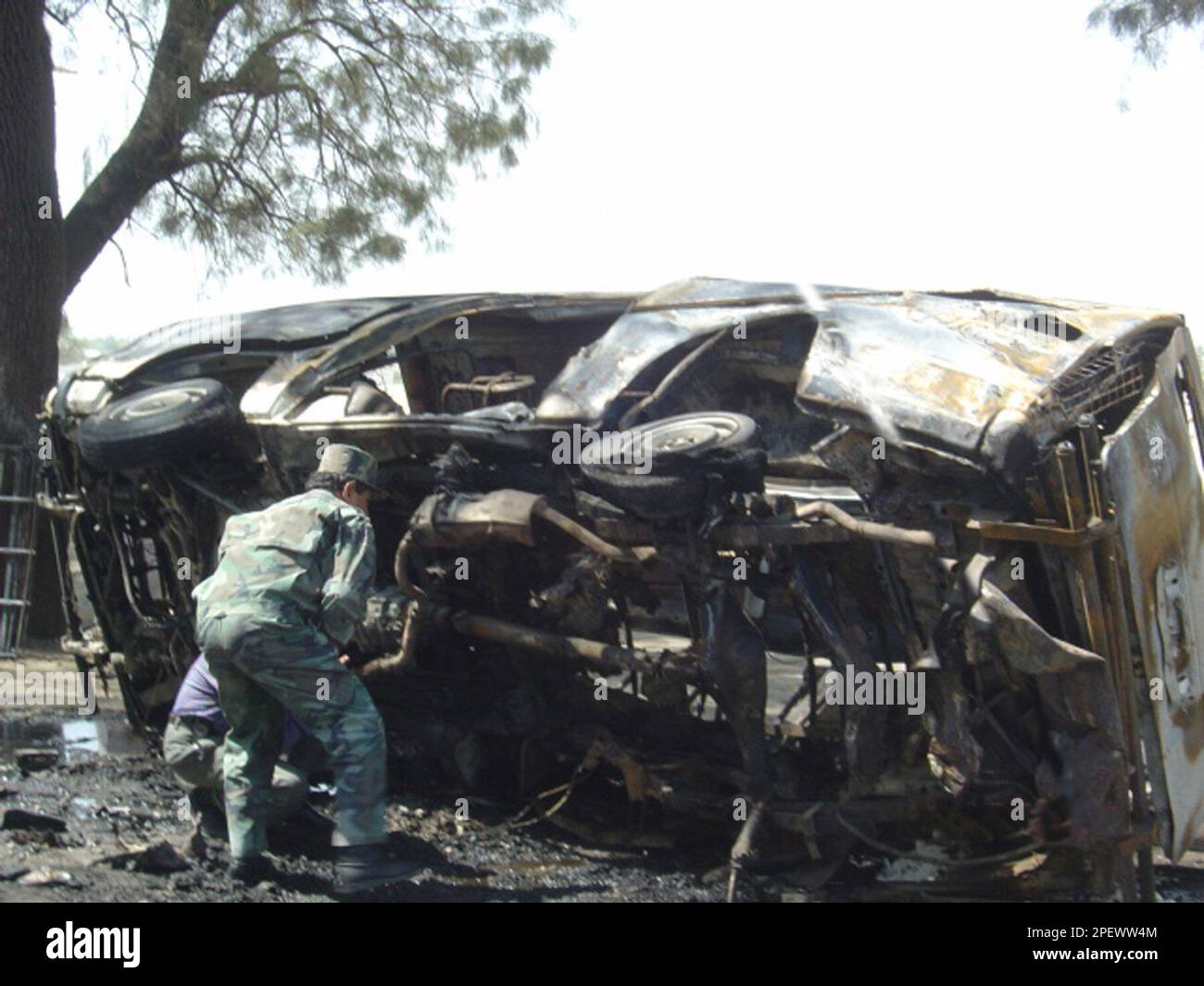 Soldiers of the Afghan army looks at the wreckage of an exploded ...