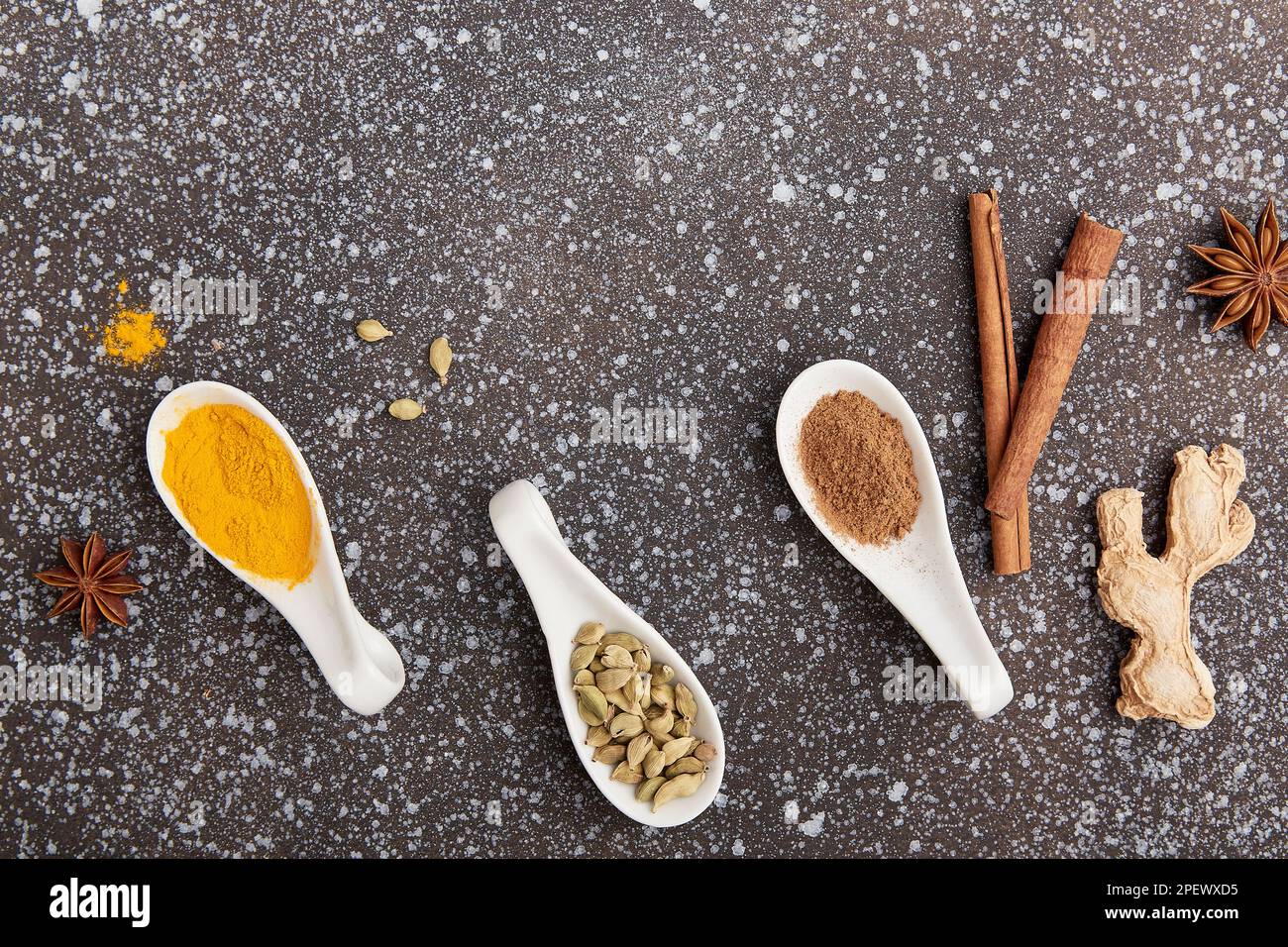 Condiments on black background - turmeric, cardamom, cinnamon, dried ...