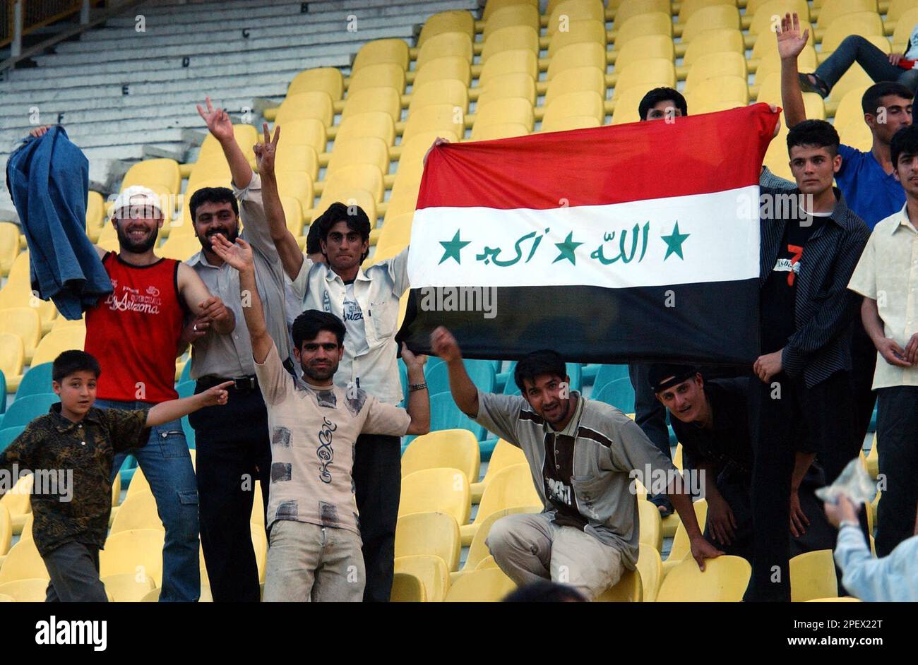 Holding their country's flag, Iraqi fans celebrate during half time of ...