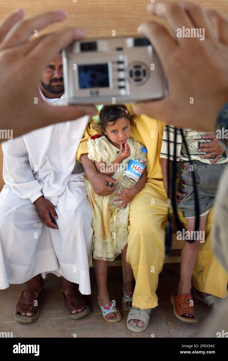 Family members pose for a photo with an Iraqi detainee, in yellow ...