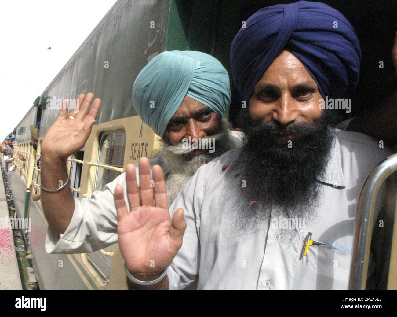 Indian Sikh devotees wave as they arrive at Wagha railyway station near ...