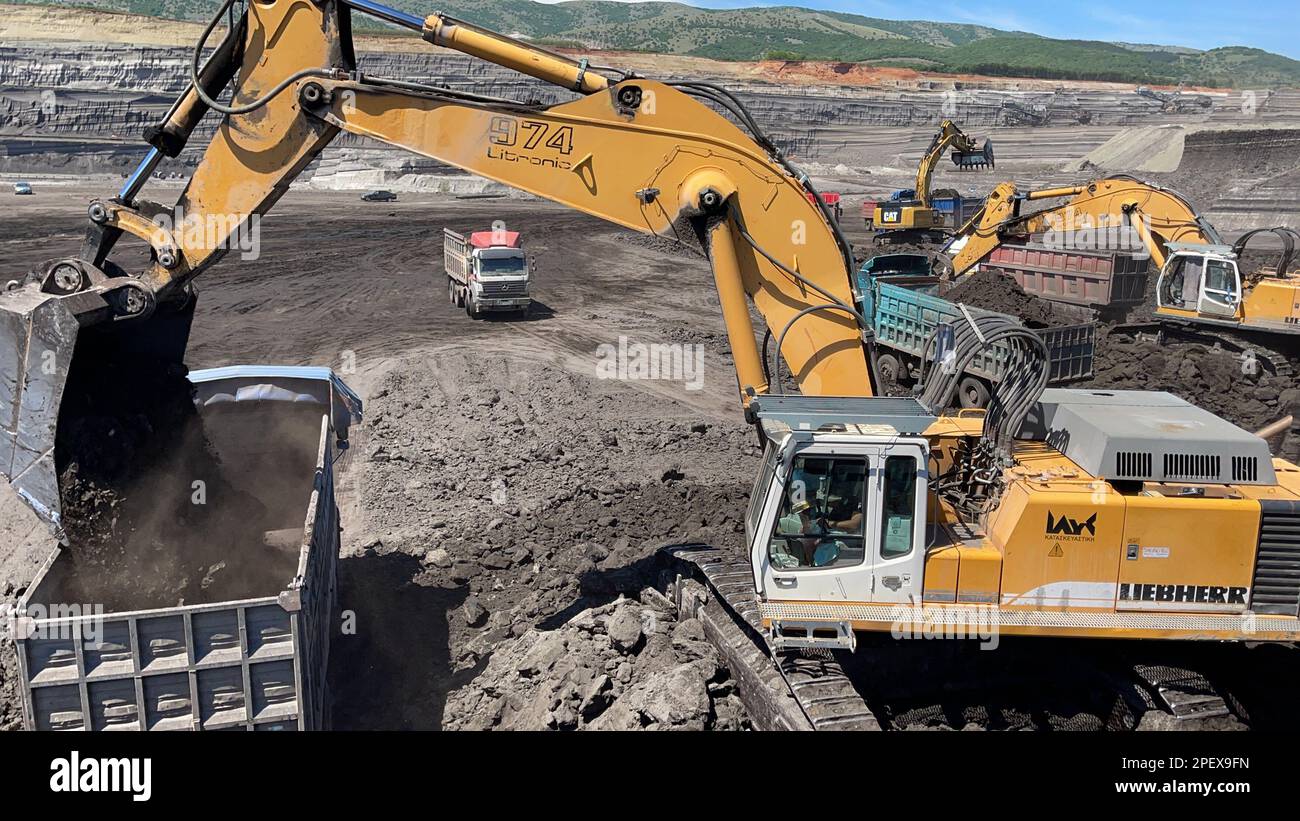 Excavators Working On Huge Mining Site, Loading The Trucks, Trucks ...