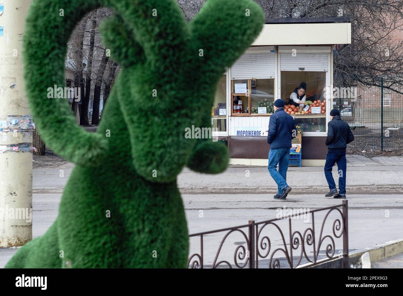 A green figurine of a ram and a vegetable stall on Voronezh street in ...