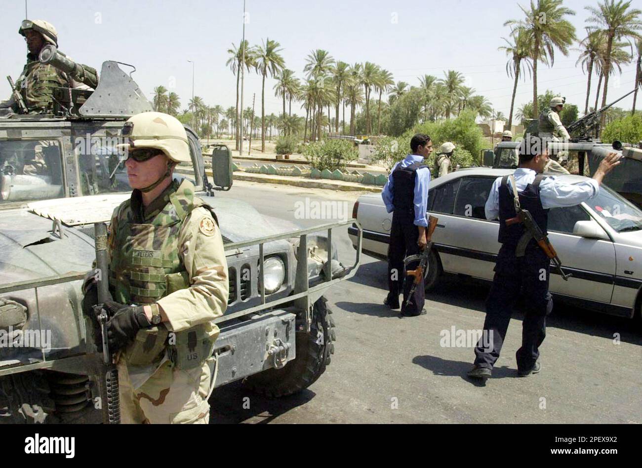 U.S. soldiers and Iraqi police man a jointly-controlled checkpoint on ...