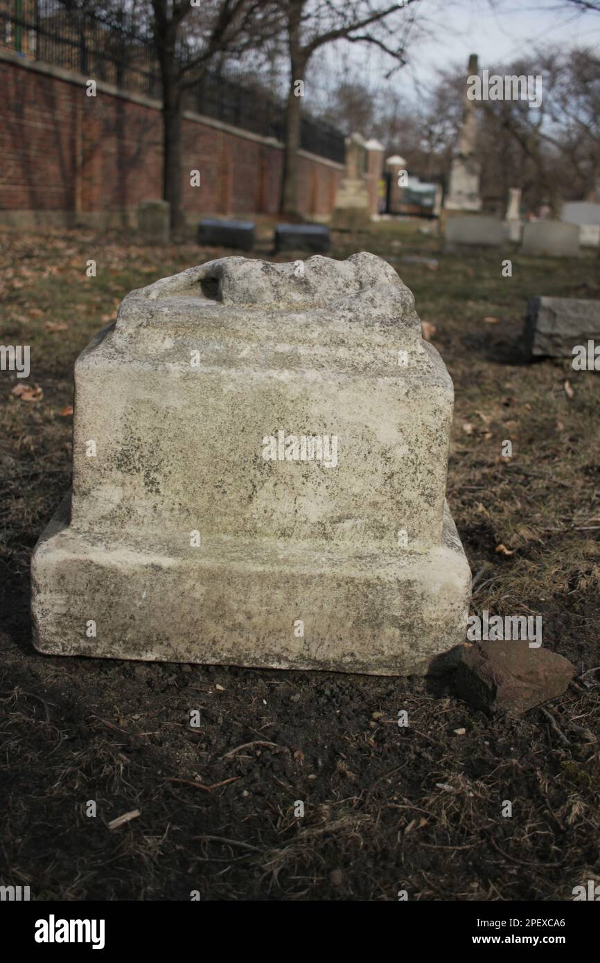 An old abandoned, weathered, and worn simple stone tombstone with a ...