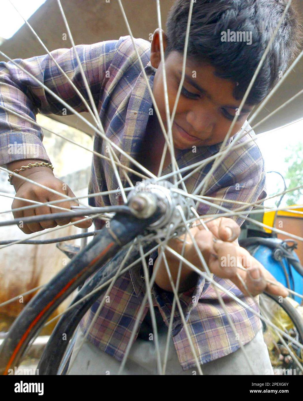 A young boy works on a tire at a garage in Allahabad, India, Friday ...
