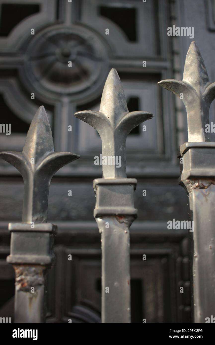 A vintage and fancy metal gate with rusted decorations and security ...