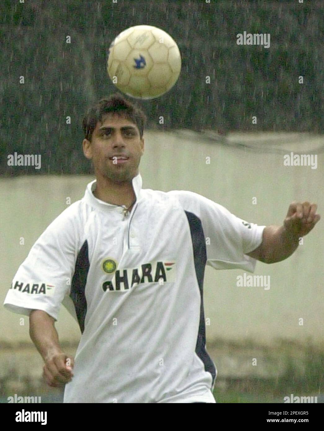 Indian cricketer Ashish Nehra plays with the ball as it rains at the ...
