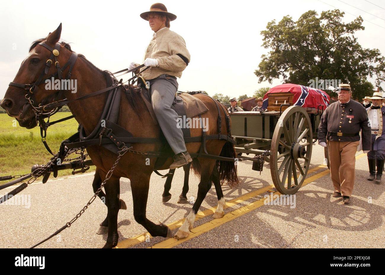 Confederate military re-enactors flank the horse-drawn coffin of ...