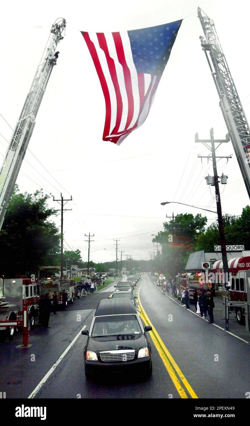 The motorcade of former President Ronald Reagan passes under a U.S ...