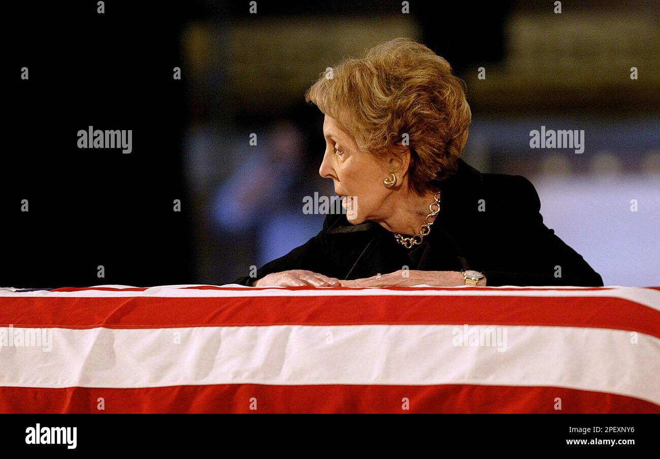Former first lady Nancy Reagan leans on the casket of her husband ...