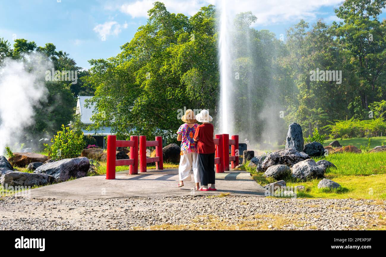 Two unidentifiable people are standing in front of hot spring at San ...