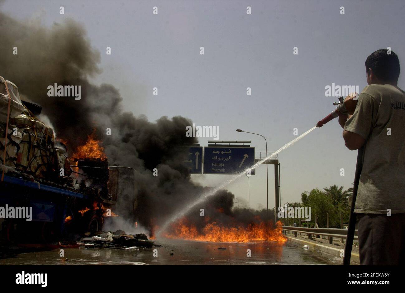 An Iraqi fire fighter tries to extinguish a burning truck carrying ...