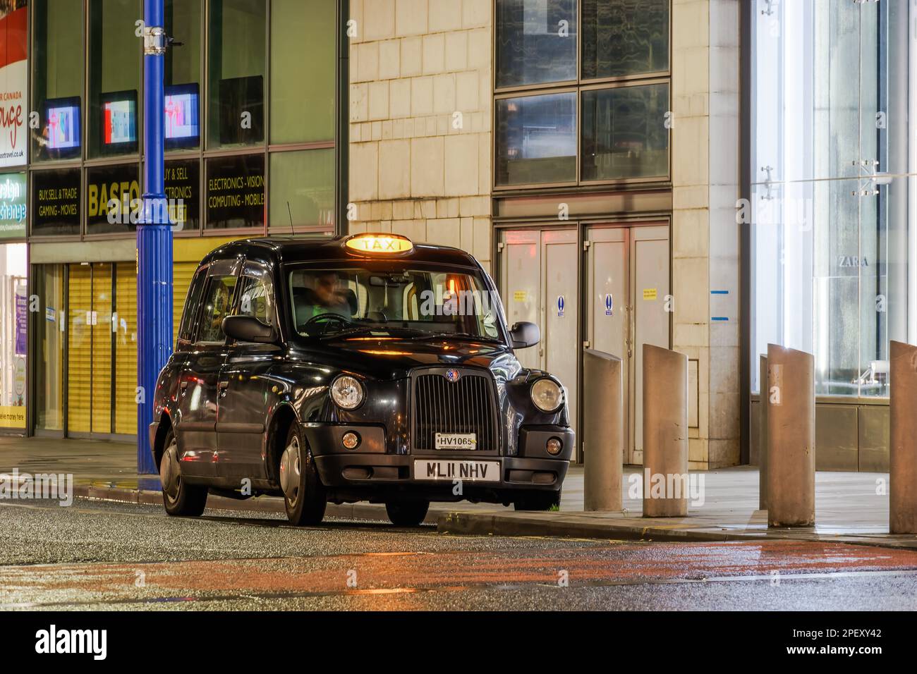Manchester, UK black traditional taxi with driver and illuminated free ...