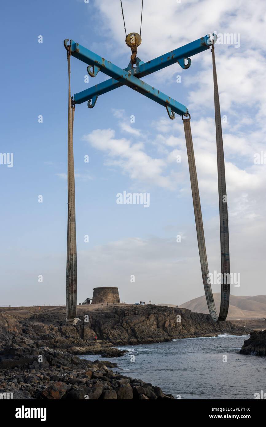 Detail of a crane and a historical tower on a hill. Blue sky with white ...