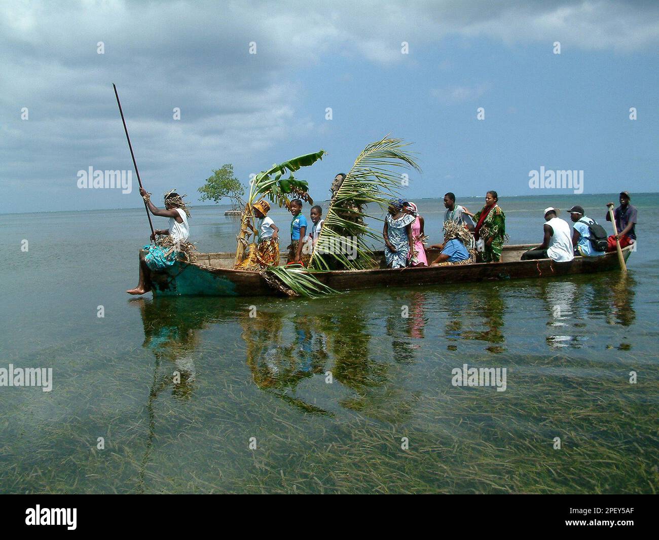 A row boat filled with Garifuna arrives at the shores of Punta Gorda ...