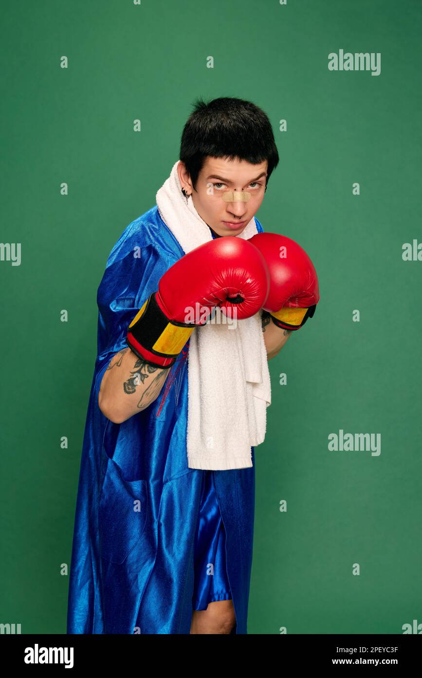 Portrait of boxer in uniform posing over green background. Concept of ...