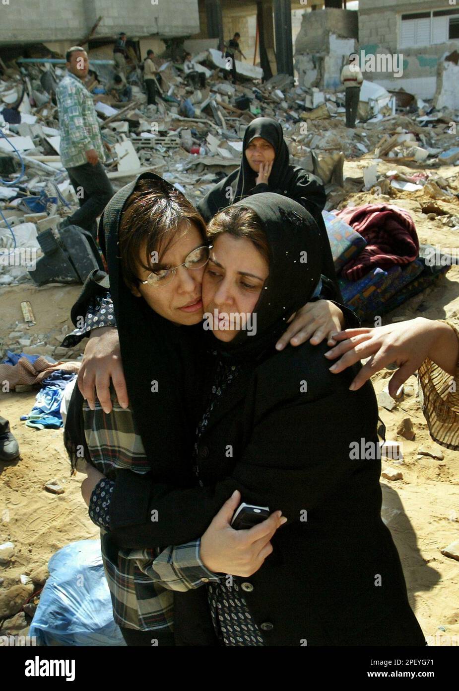 Palestinian women from the Awad family embrace as they weep in front of ...