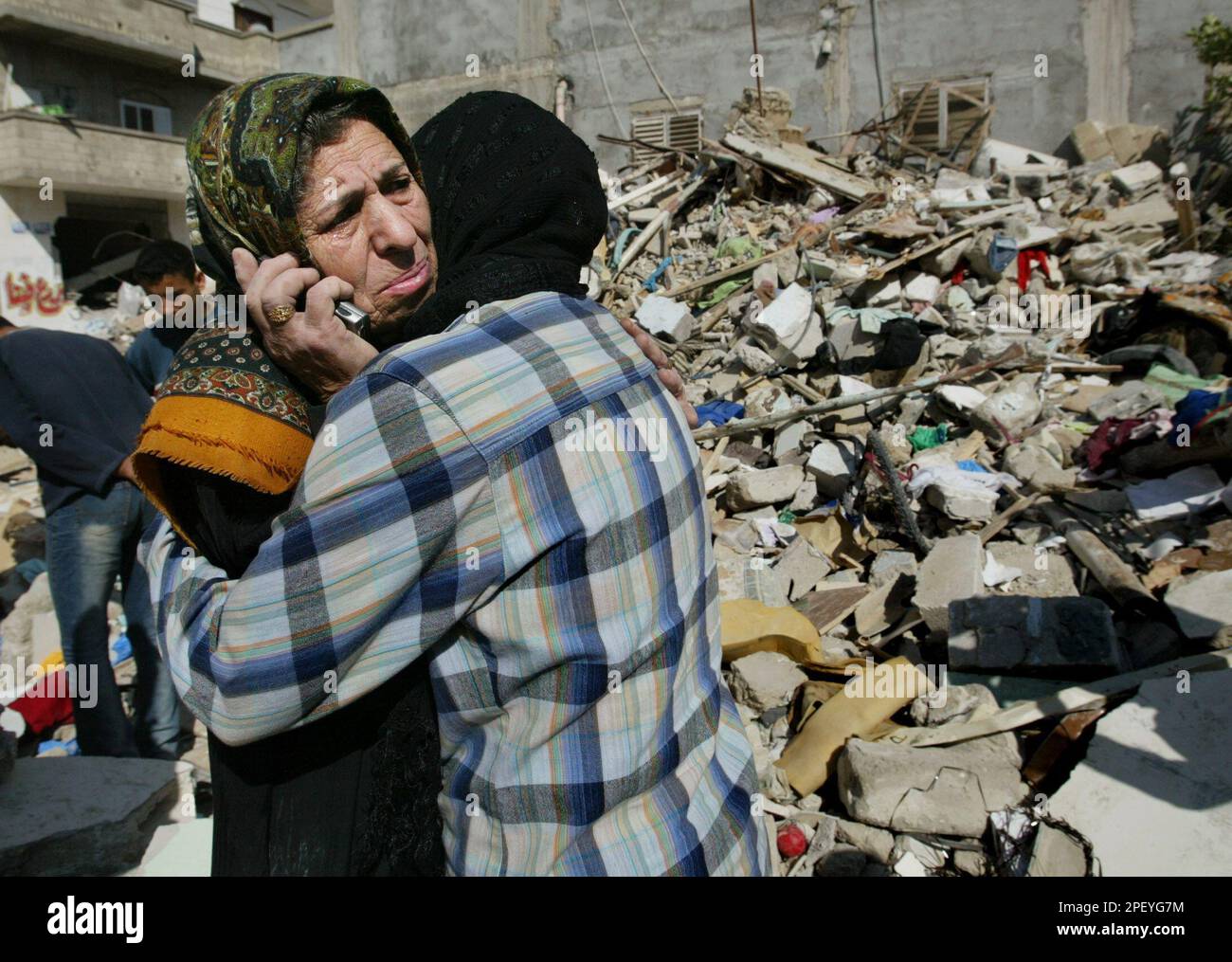 Palestinian women from the Awad family embrace as one speaks to ...