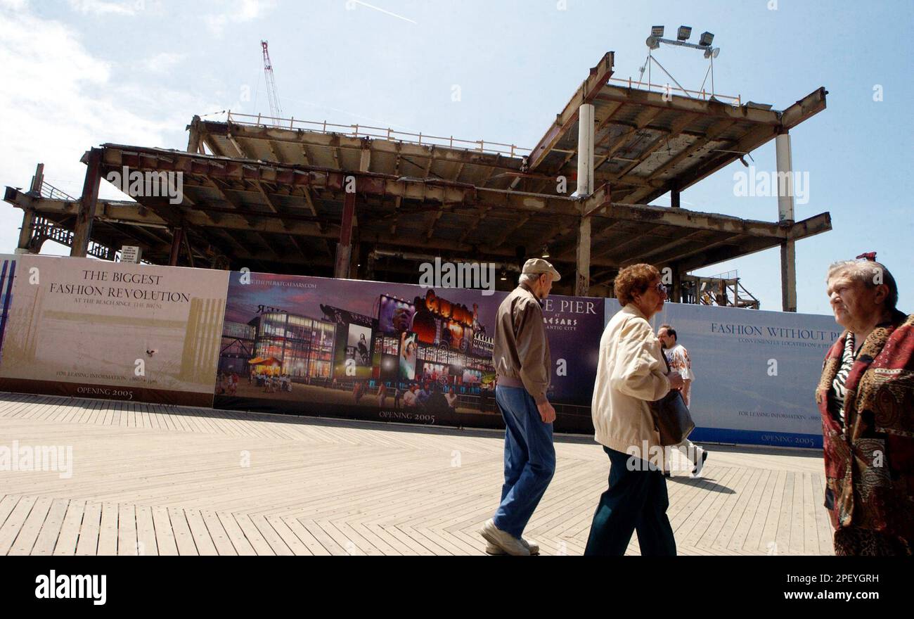 Persons walk the Boardwalk in front of the skeleton of the former Ocean ...