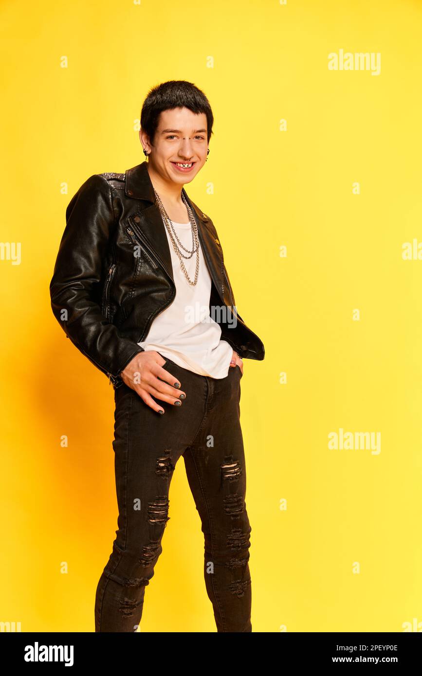 Young man guy with piercing keeping hand at pocket and posing at camera ...