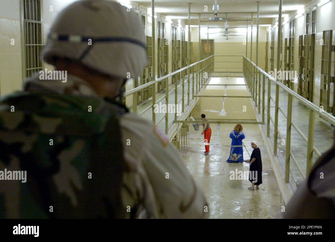A U.S. Army military police officer supervises as Iraqi detainees clean ...