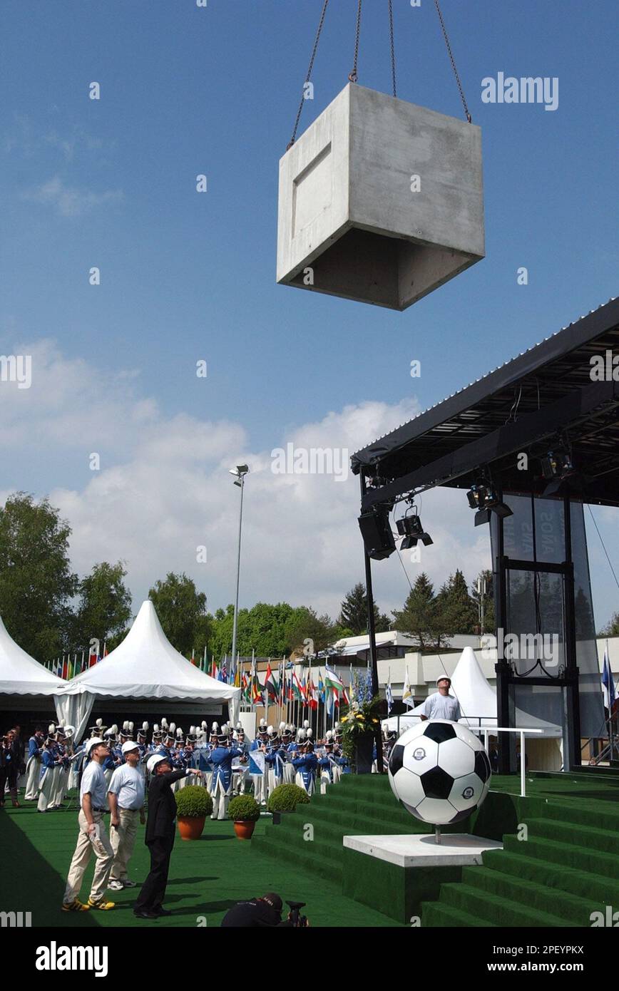 A concrete block is lowered onto an oversized football during the ...