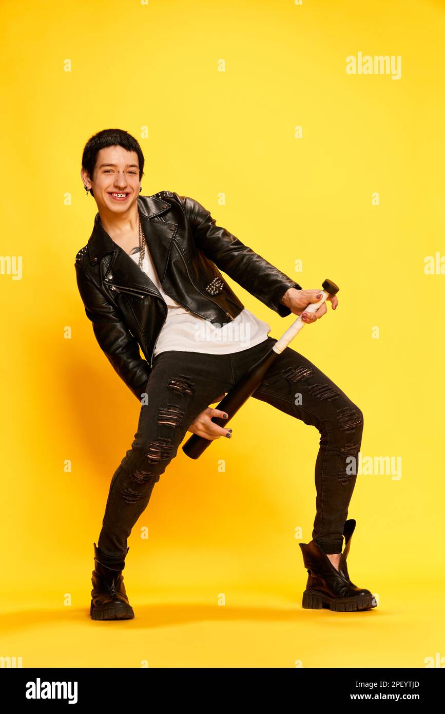 Punk young guy with baseball bit like playing guitar and smiling at ...