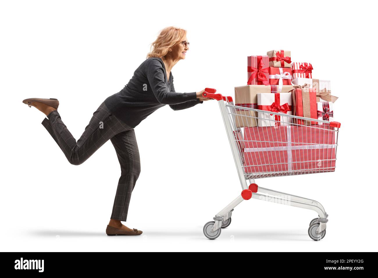 Full length profile shot of a woman running with a shopping cart full ...