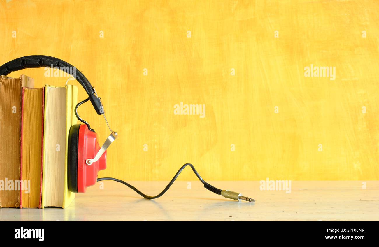 audio book concept with row of books,and vintage headphones,yelloow ...