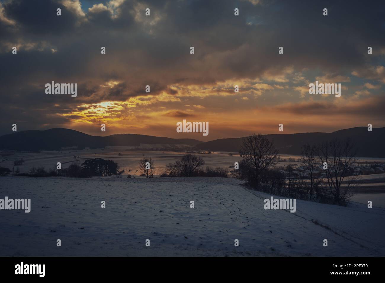 sunset at winter with snowy field and some mountains in the background ...