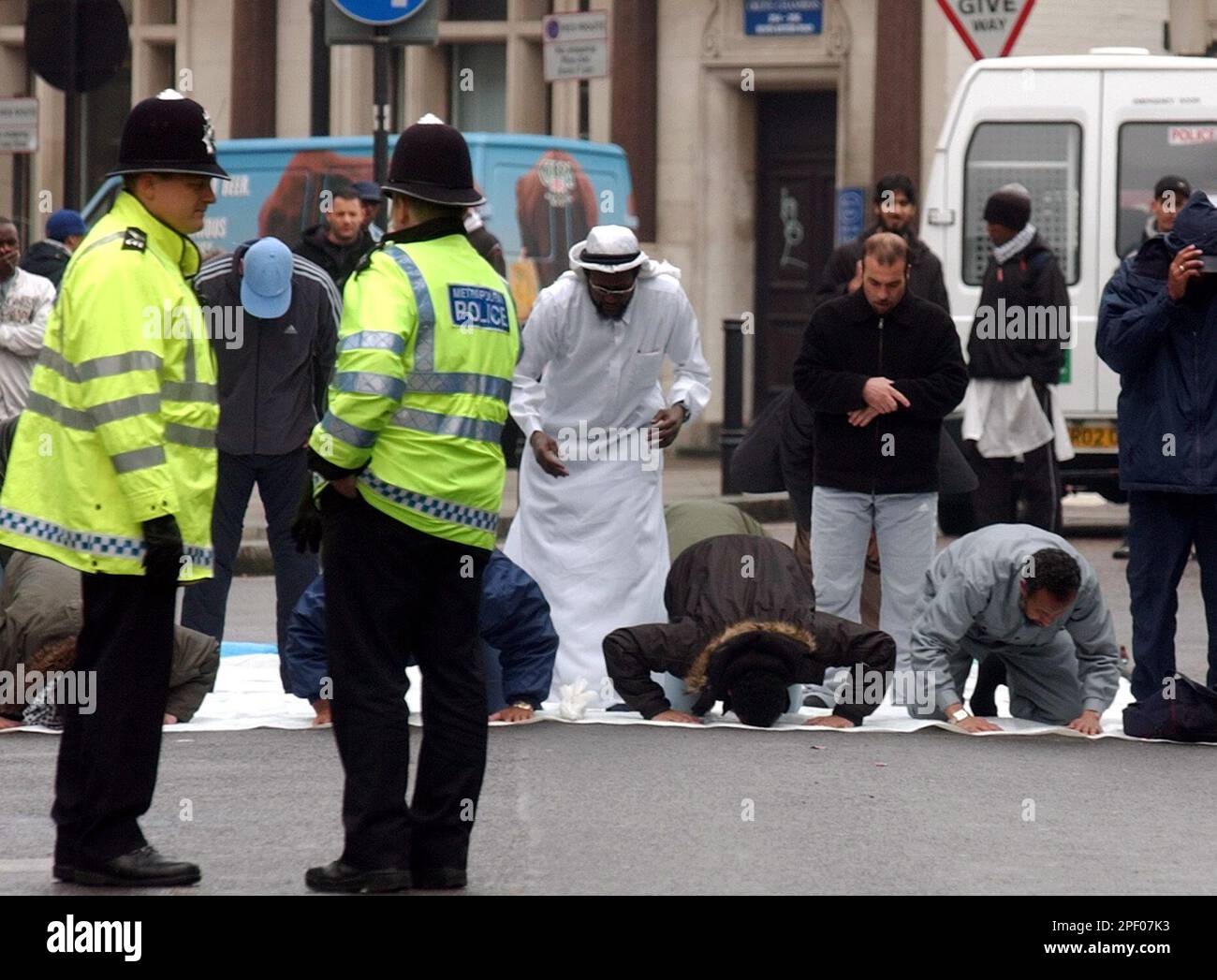 Two British police officers stand near Muslim faithful attending Friday ...