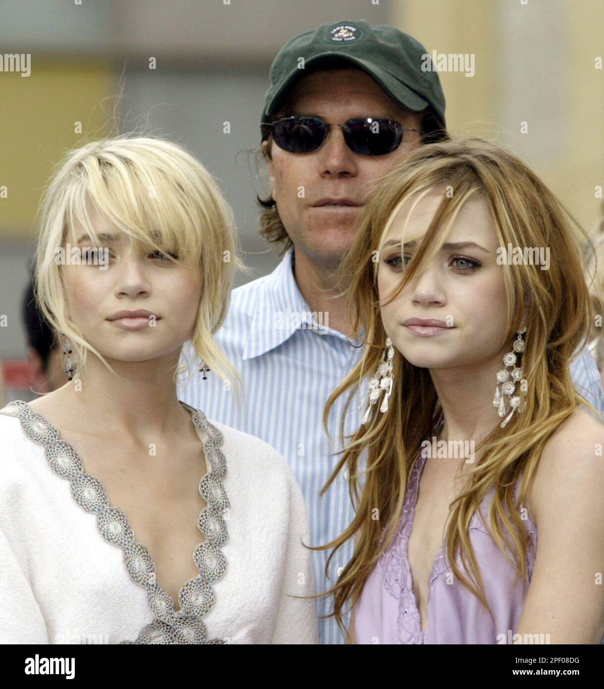 Celebrity twins Mary-Kate, right, and Ashley Olsen pose with their father David Olsen, center ...