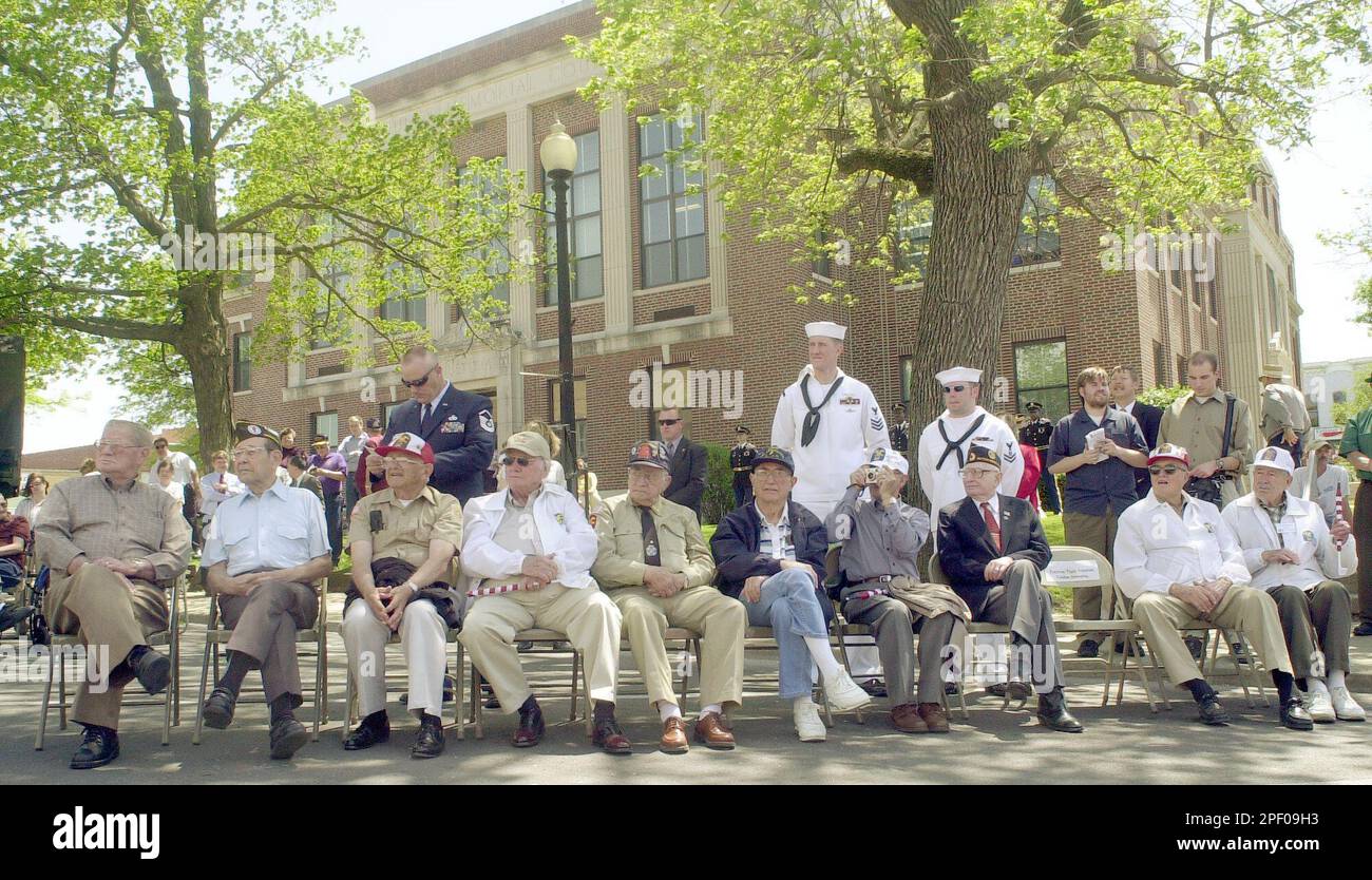 Ten survivors of Exercise Tiger, seated, listen during a ceremony ...