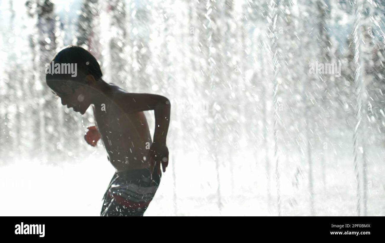 Happy kid having fun at water park jets in 120fps slow motion during ...