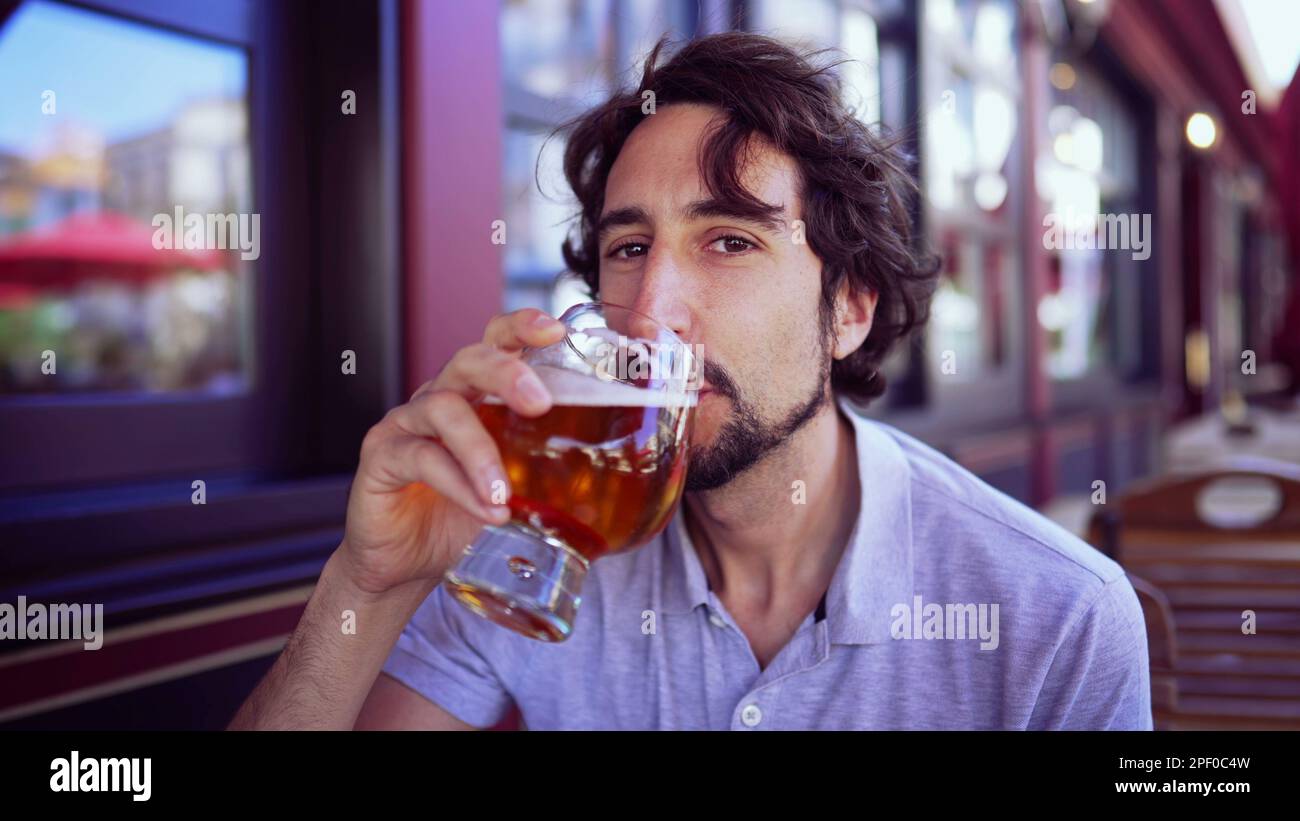 Happy person drinking beer outdoors smiling at camera. Portrait of one ...
