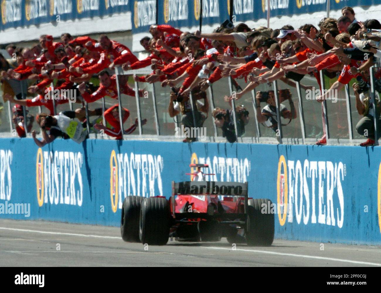 Ferrari technicians celebrate as Germany's Michael Schumacher crosses ...