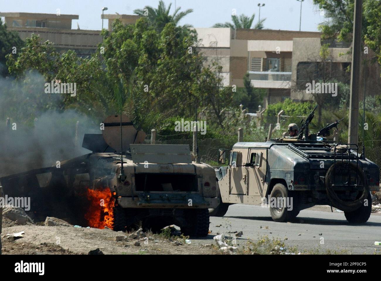 A U.S Army Humvee stands guard next to a burning Army Humvee which was ...